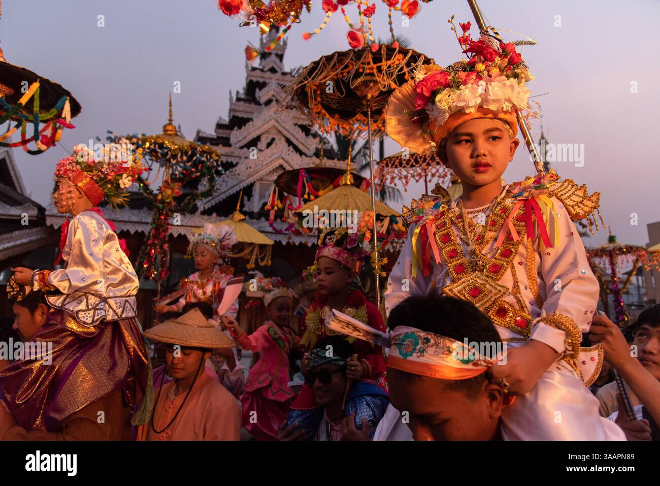 Young ethnic Shan boys dressed in colorful costumes are seen carried on ...