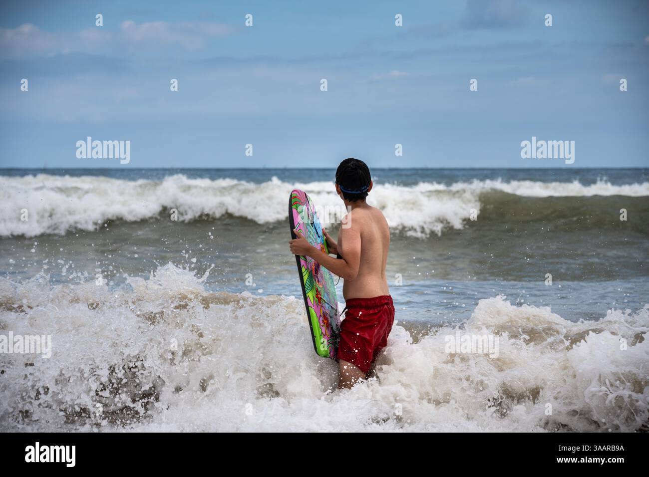 11 year old boy with colourful bodyboard Stock Photo - Alamy