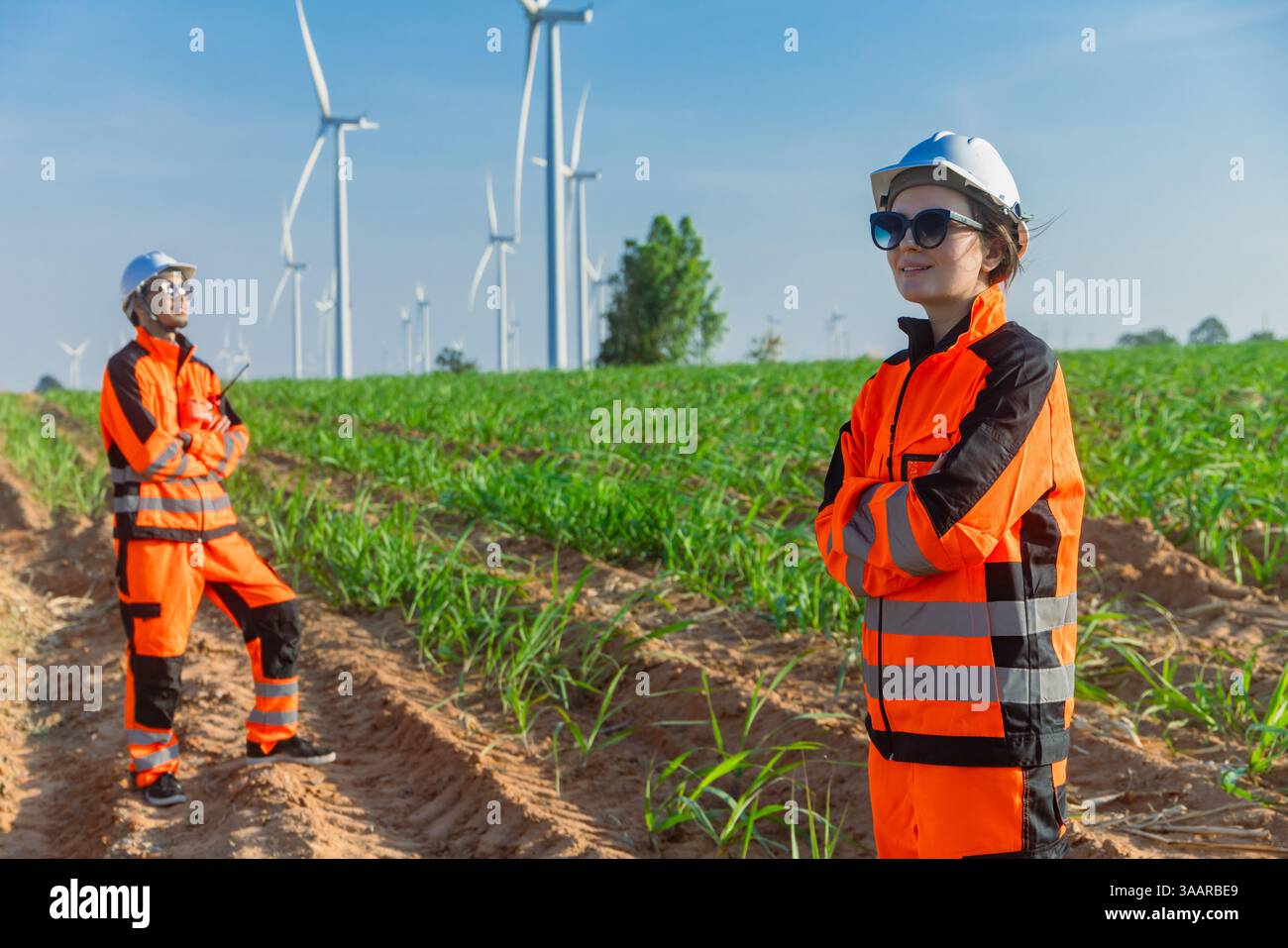 Engineer young worker team standing confident arm crossed at agriculture wind turbine farm ...