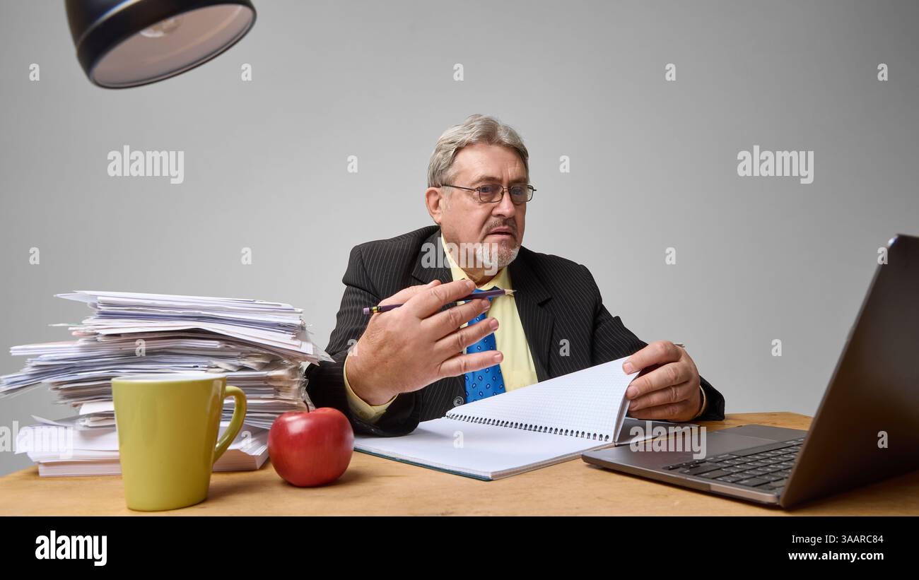 Senior teacher explaining information with gesture during online lesson ...