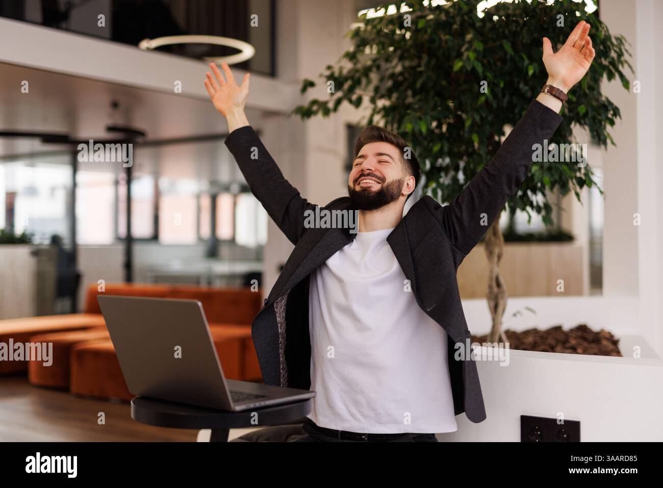 Excited screaming young man looking at the screen of his computer and ...
