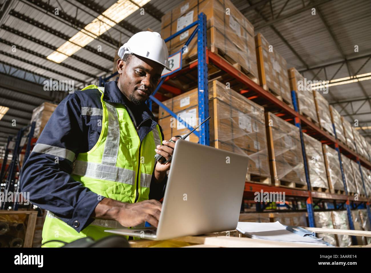 african black professional warehouse worker. stock inventory staff using computer check stock ...