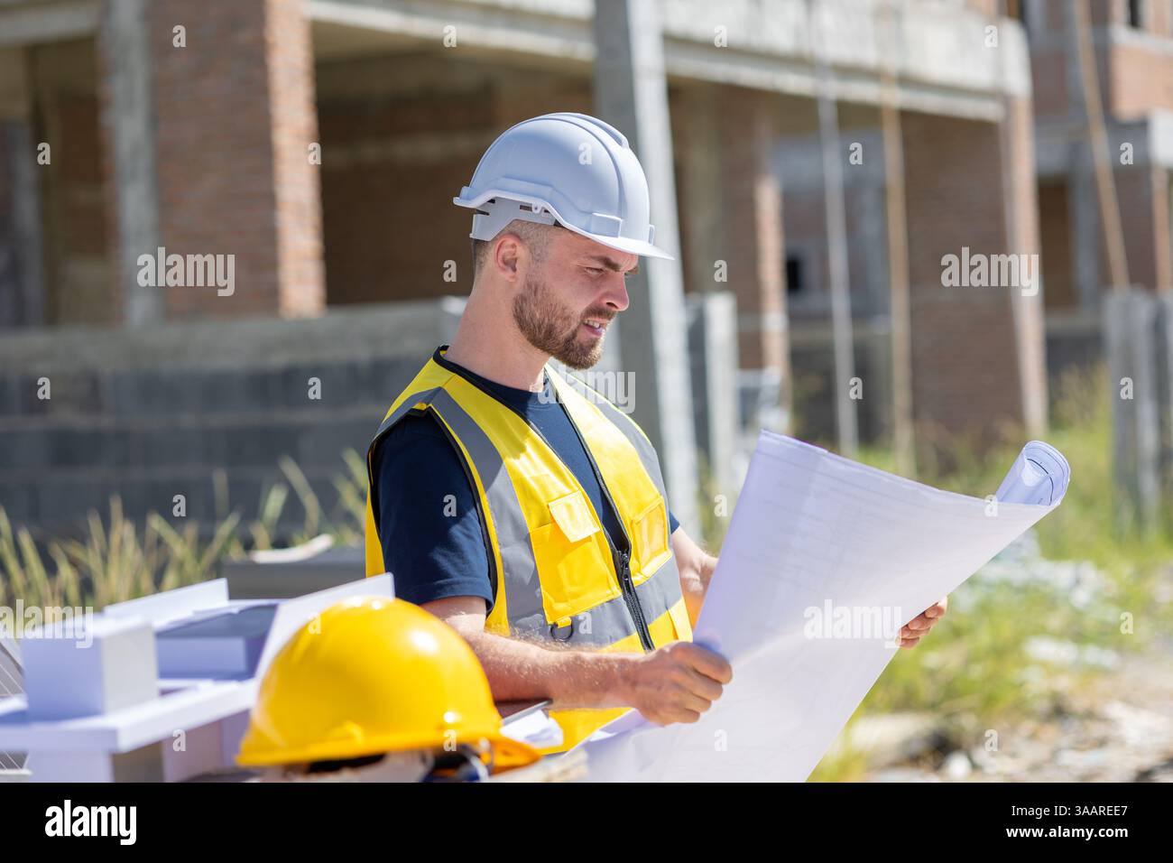 Construction worker with floorplan. Caucasian engineer male wearing ...