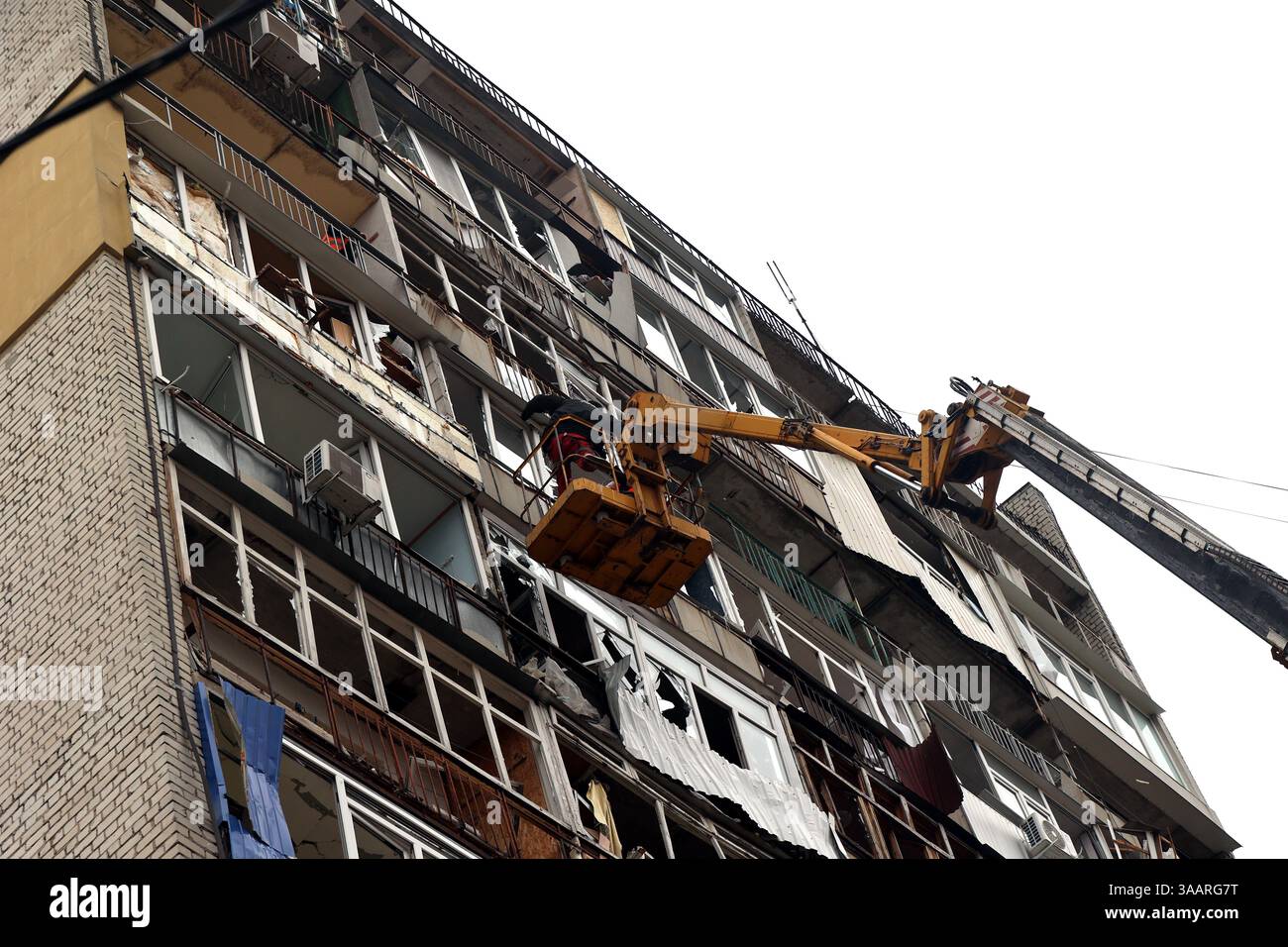 Municipal workers use an aerial work platform to reach an apartment ...