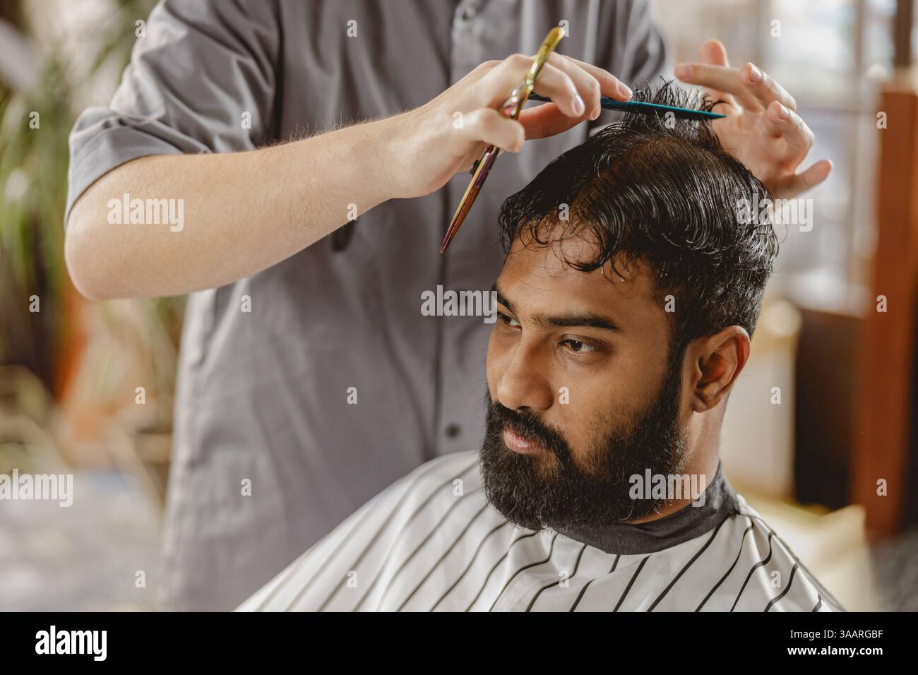 A Professional Barber styles hair in a modern, chic salon that offers ...