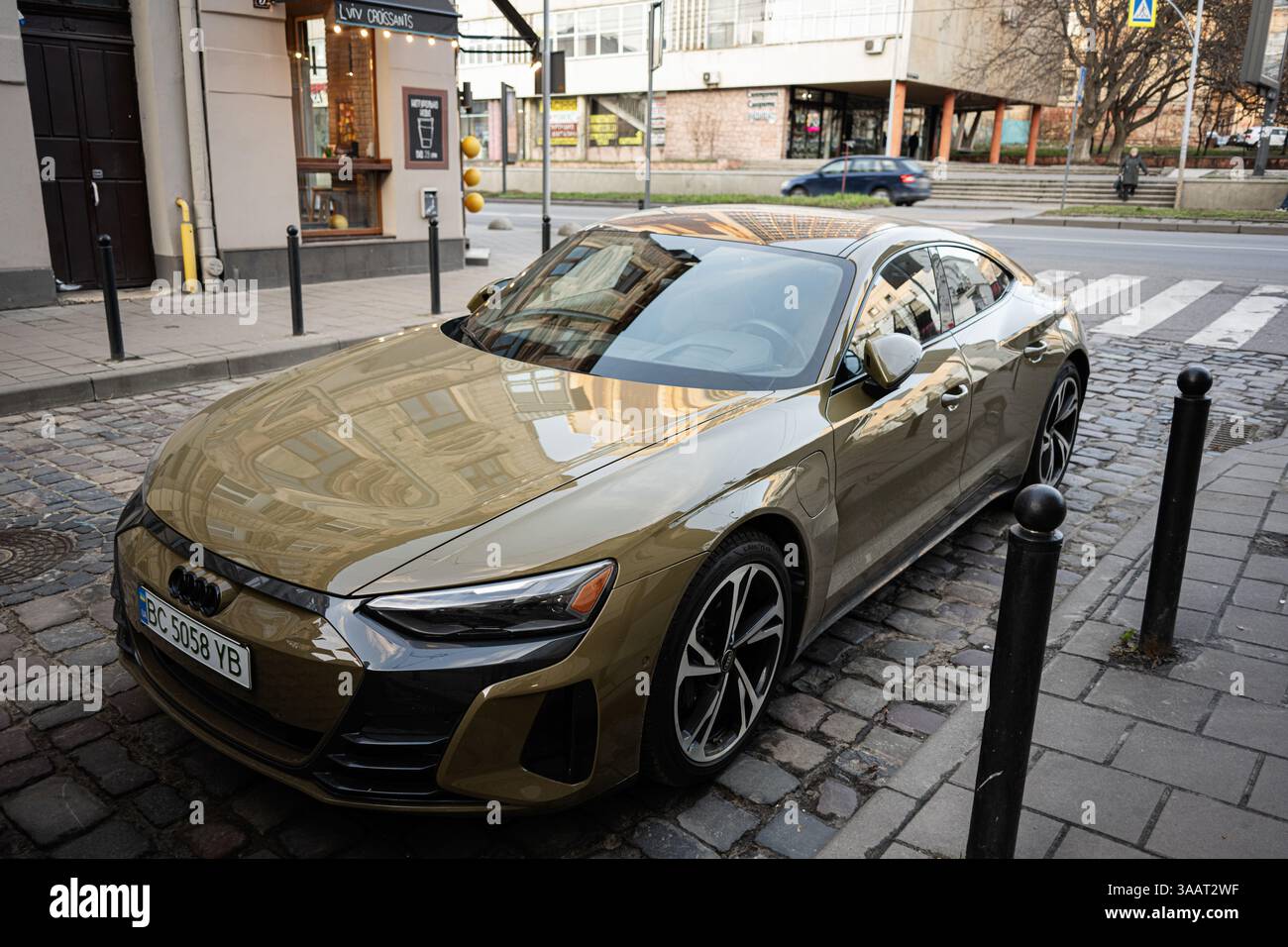 Lviv, Ukraine - March 31, 2025: Sleek Audi E-tron GT gold car by a shop ...