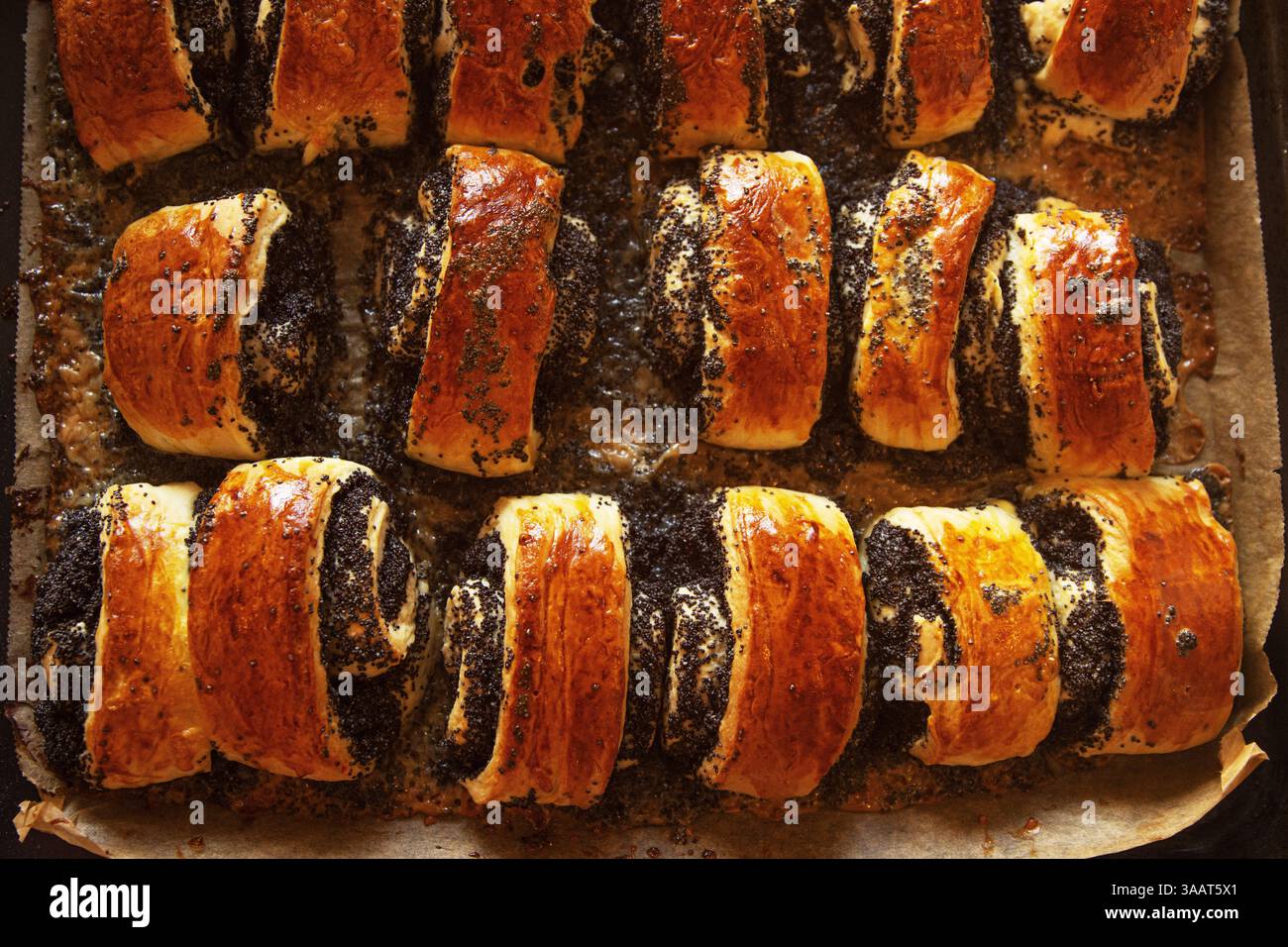Top view of freshly baked poppy seed roll pastries with a chocolate ...