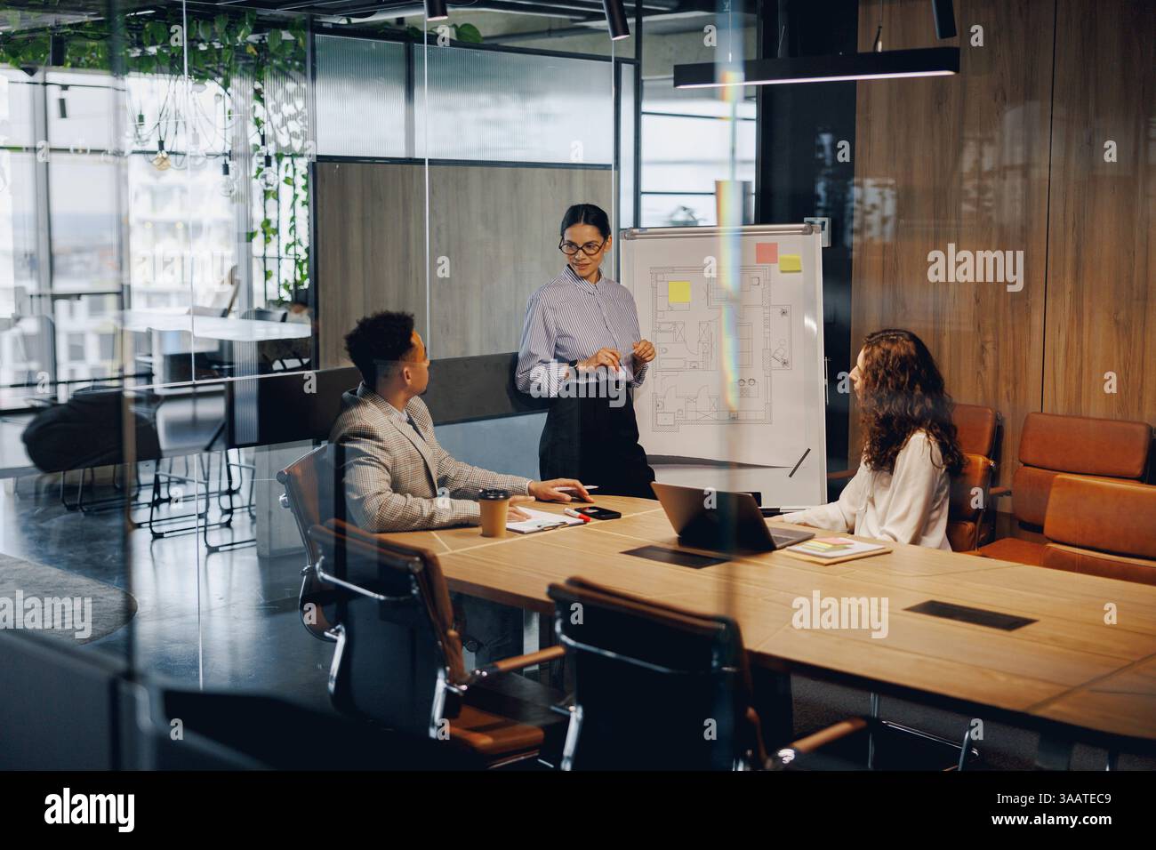 A dynamic meeting occurs in a modern office designed for collaboration ...