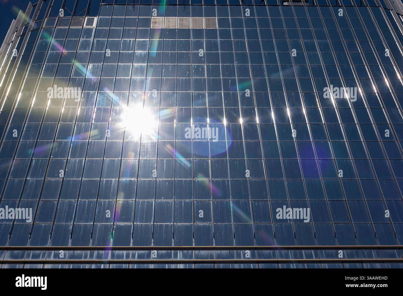 Bright sun reflecting in the windows of a tall skyscraper. Bright white ...