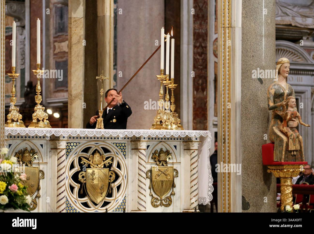An operator lighting the candles while Pope Francis (Jorge Mario ...