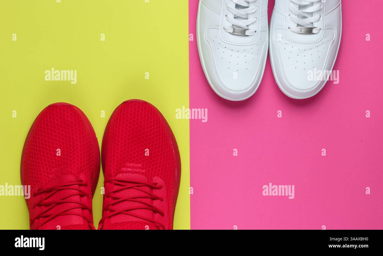 Two pairs of sneakers on a neon color background. White and red shoes ...