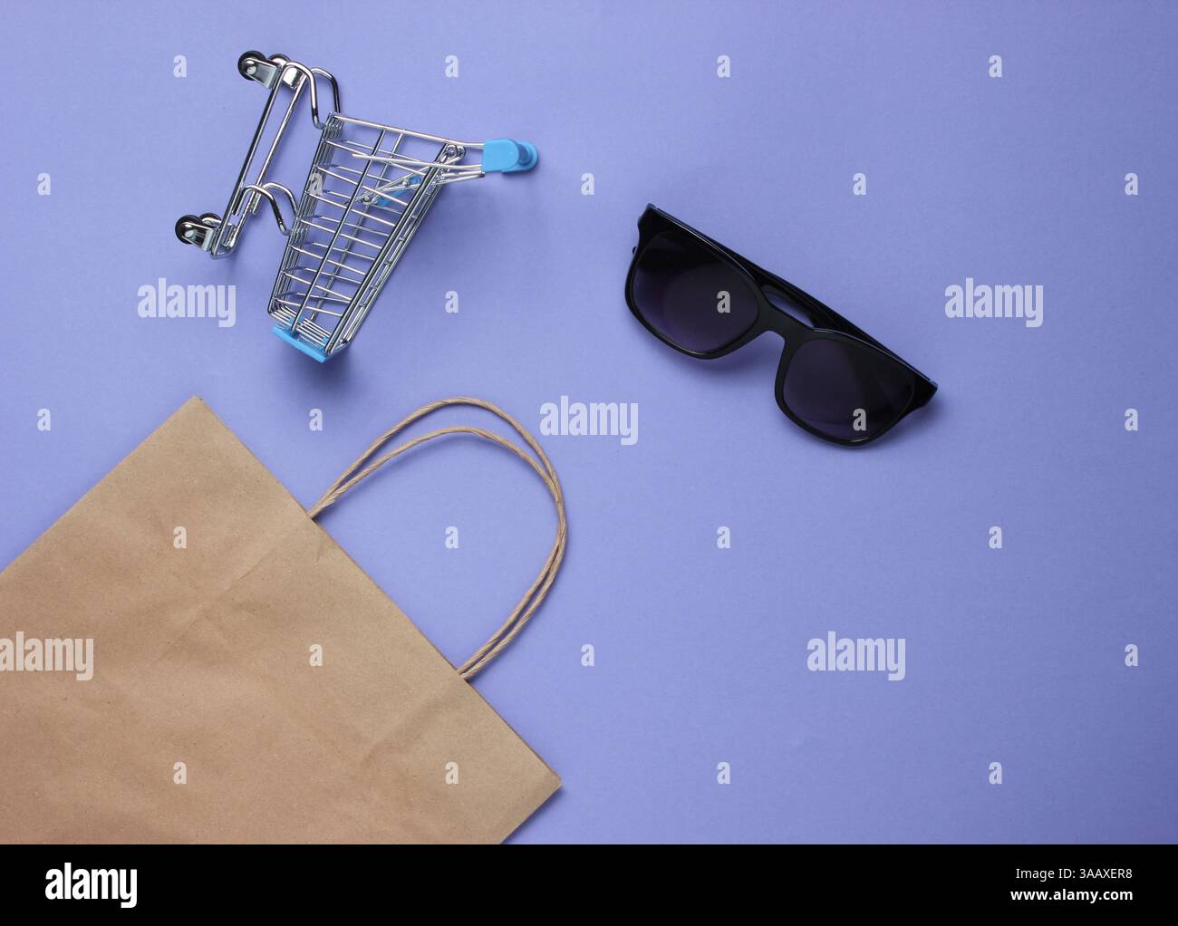 Minimalism shopping concept. Paper shopping bag, mini shopping cart and ...