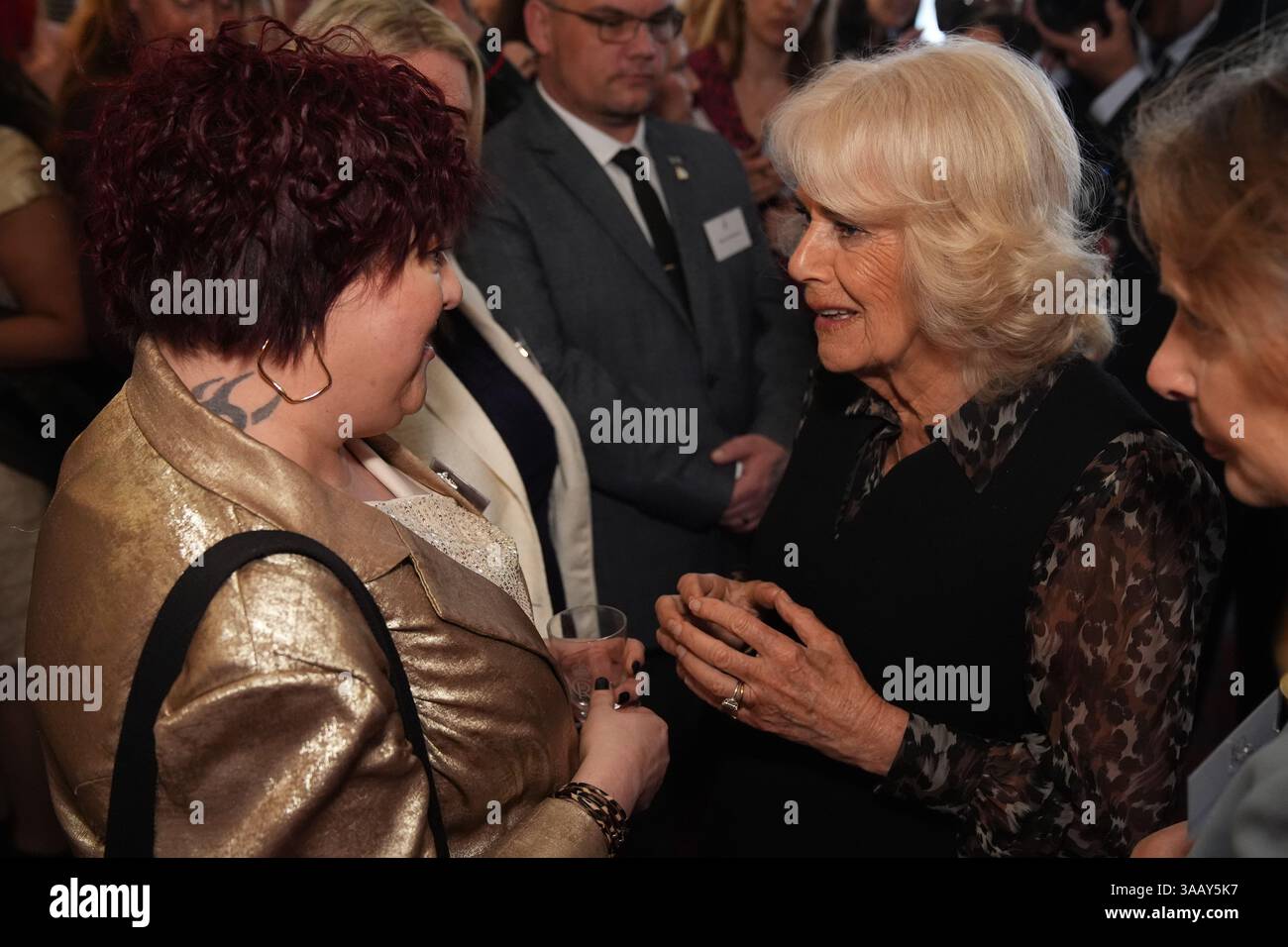 Queen Camilla (right), patron of SafeLives, speaks to Saskia Lightburn ...