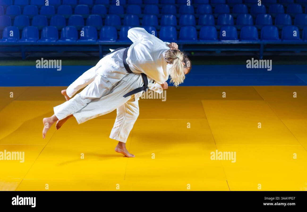 Martial arts. Sparing Portners. Sport man and woman in white kimono train judo throws and ...