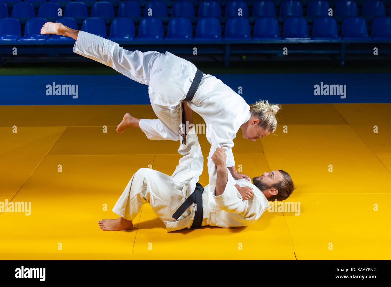 Martial arts. Sparing Portners. Sport man and woman in white kimono train judo throws and ...