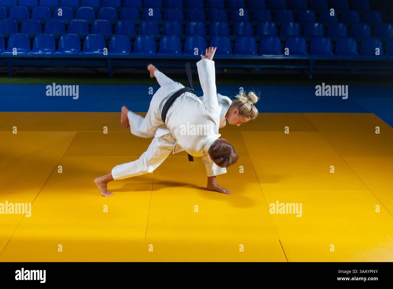 Martial arts. Sparing Portners. Sport man and woman in white kimono train judo throws and ...