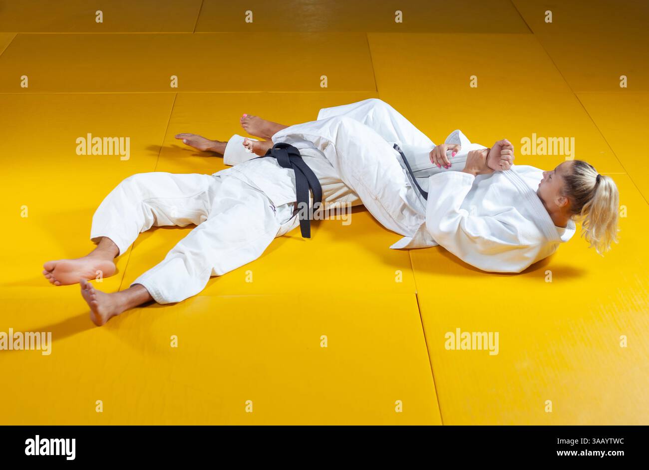 Martial arts. Sparing Portners. Sport man and woman in white kimono train judo throws and ...