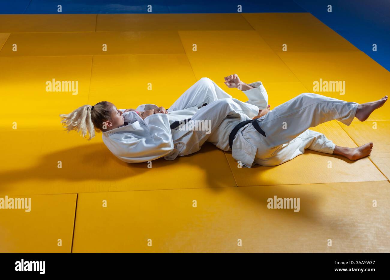 Martial arts. Sparing Portners. Sport man and woman in white kimono train judo throws and ...