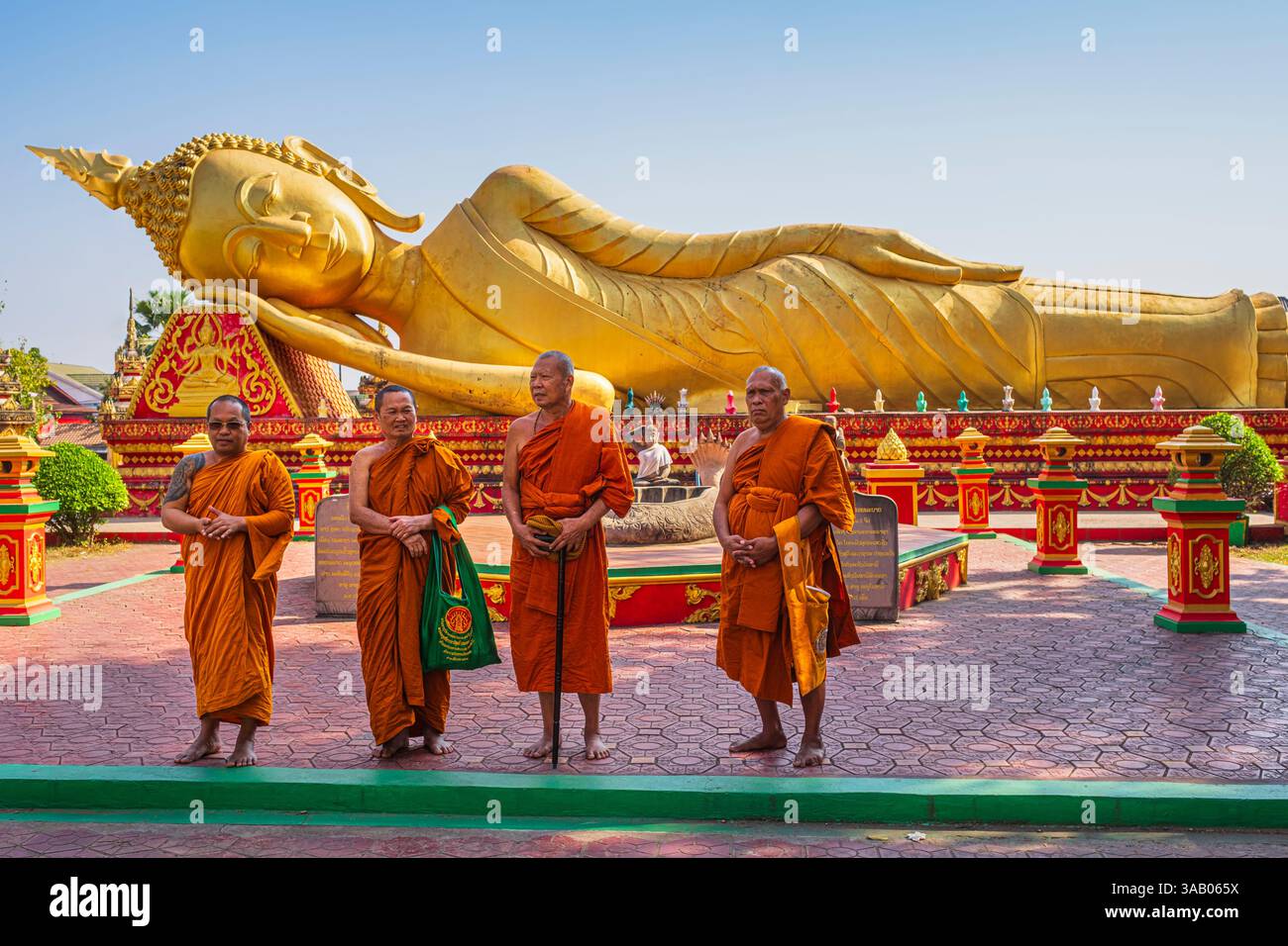 Laos, Vientiane, Buddhist monks and lying Buddha in the Wat That Luang ...