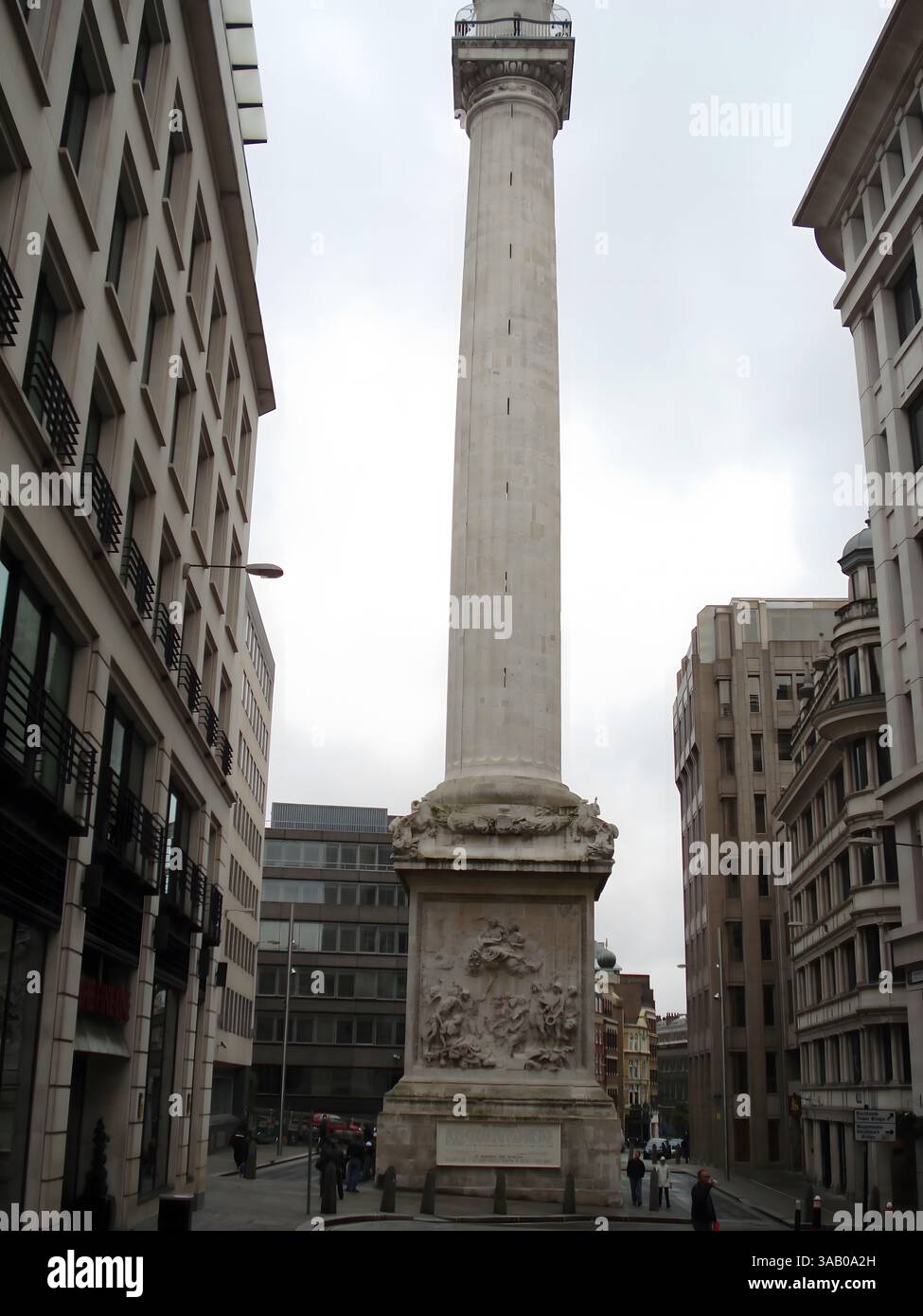 A tall, white column stands prominently at the end of a street ...