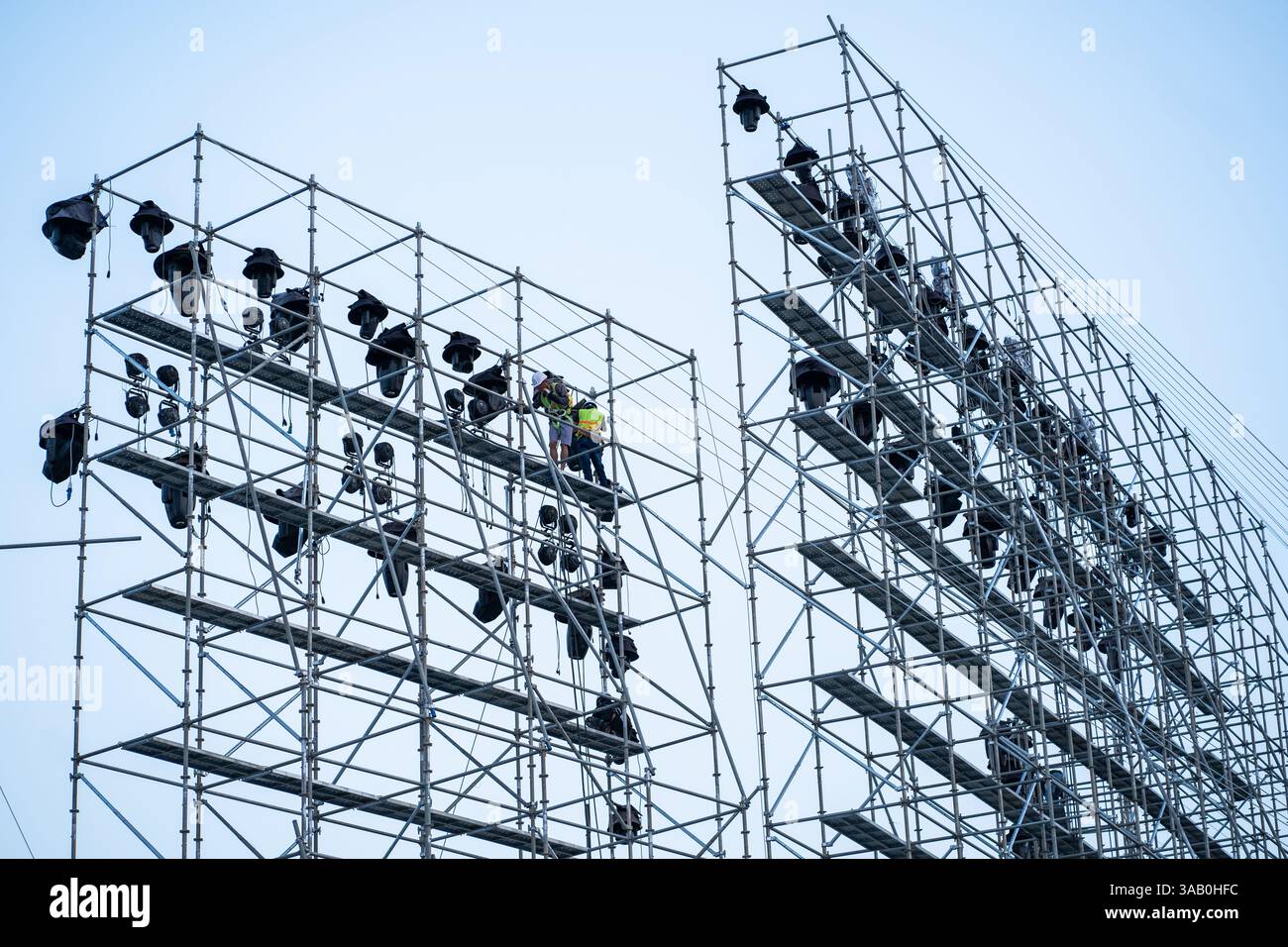 construction workers assembling large scaffolding and metal rigs for ...