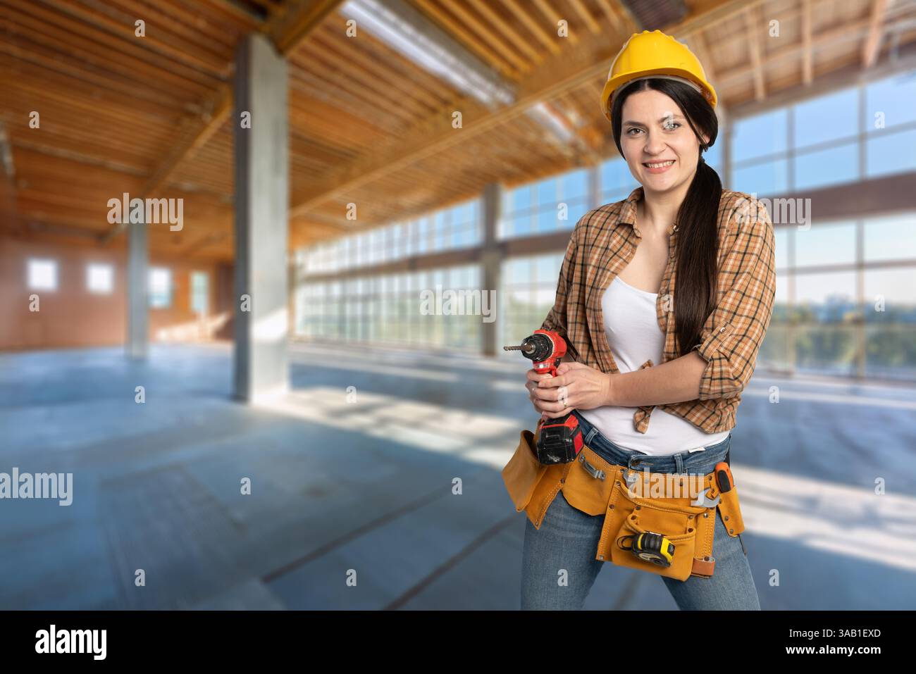 Confident female construction worker holding an electric drill hi-res ...