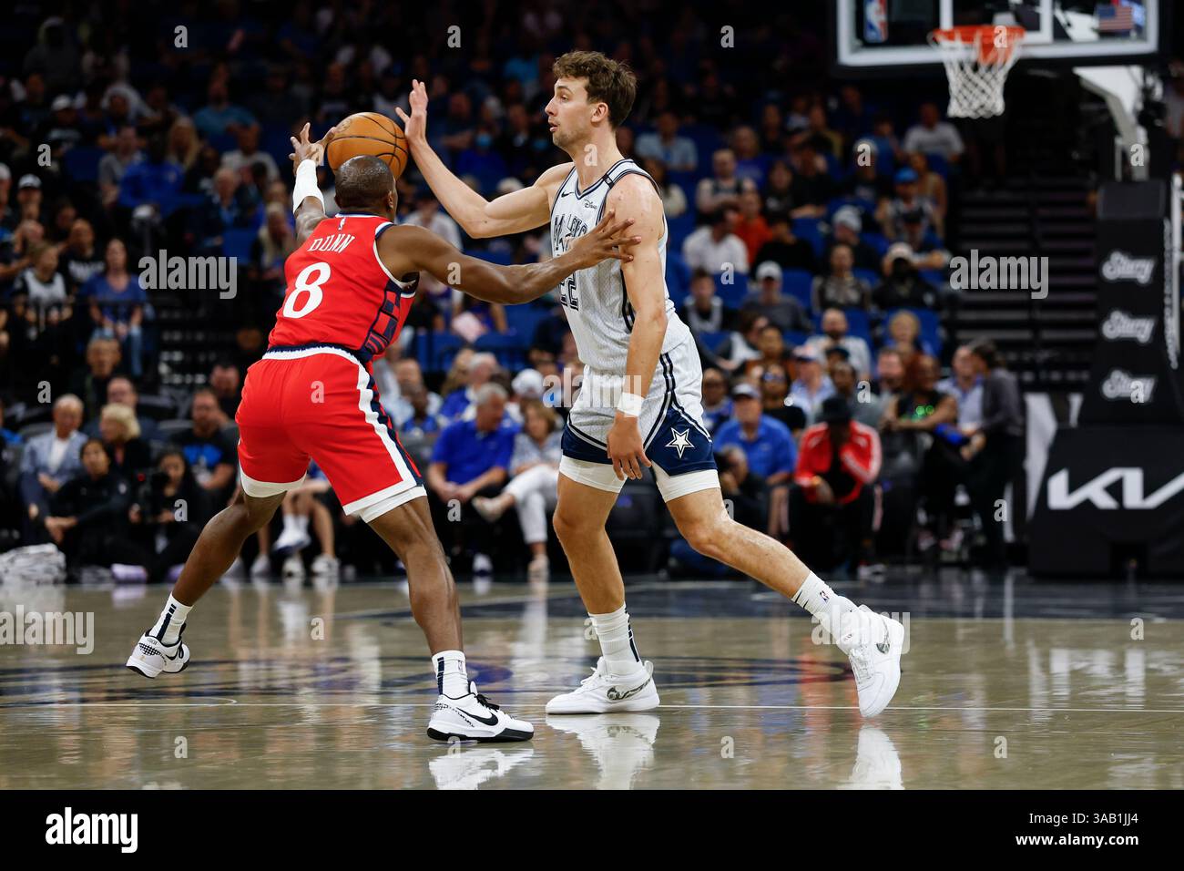 Los Angeles Clippers guard Kris Dunn (8), left, blocks Orlando Magic ...