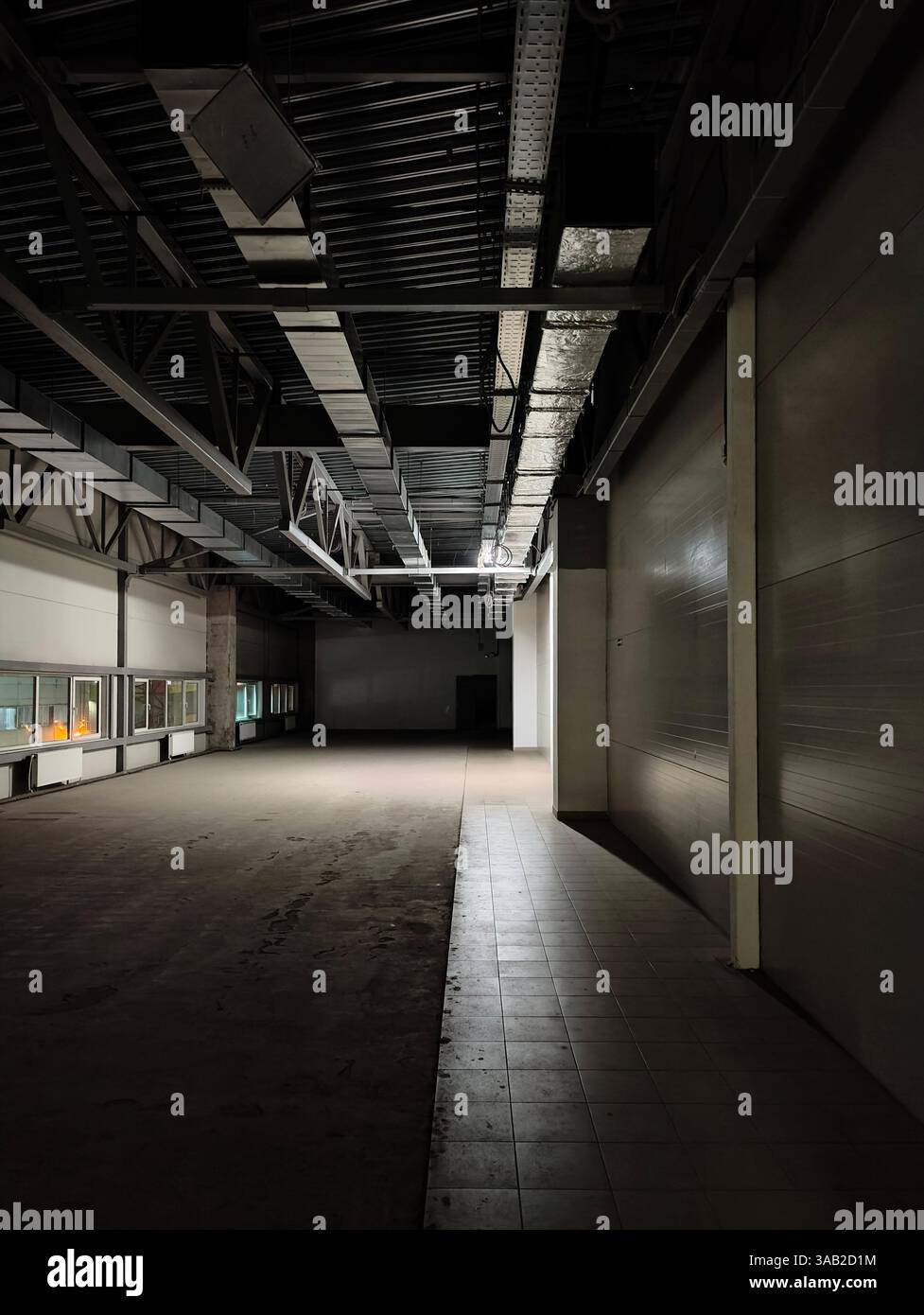 Dimly Lit Industrial Interior with Overhead Pipes and Ducts Stock Photo ...