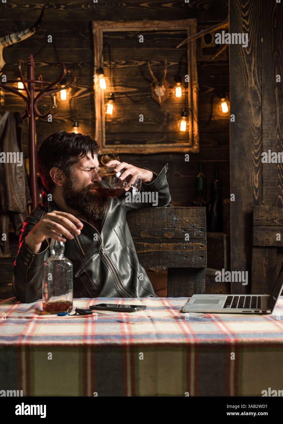 Bearded handsome man holding glass of wiskey. Wasted and depressed ...