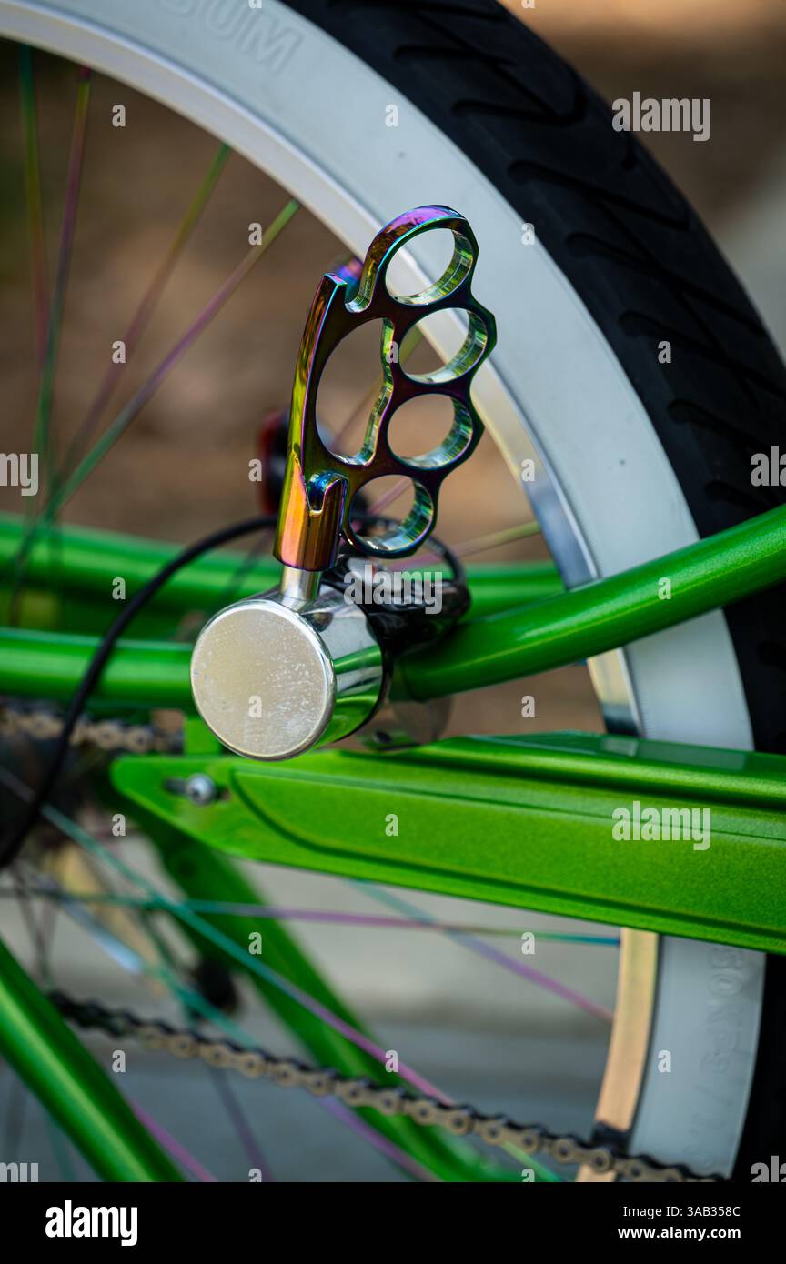 A set of brass knuckles attached to part of a bright green "lowrider ...