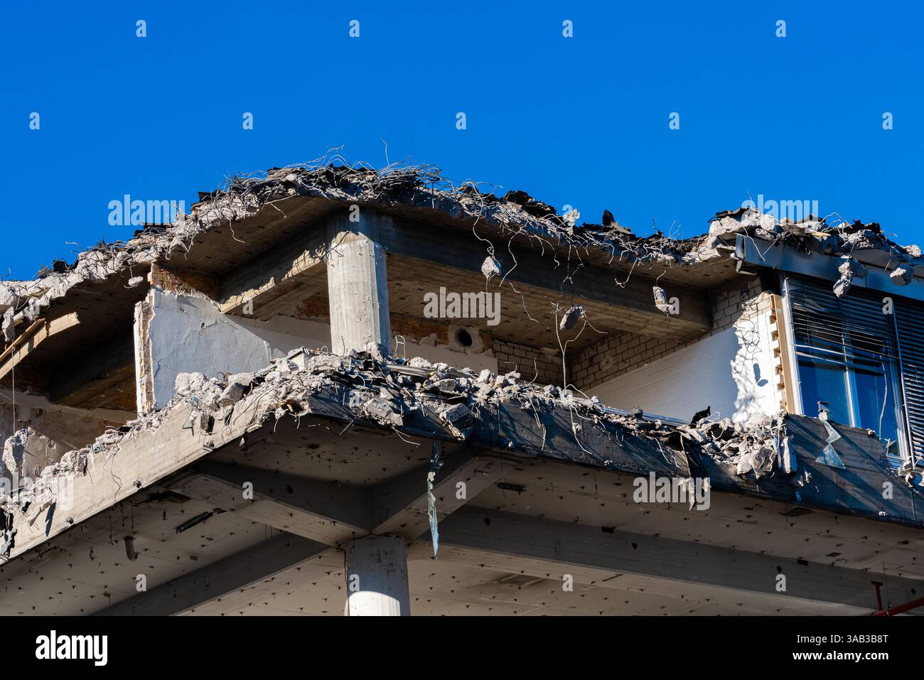 A partially demolished building reveals exposed structures and debris ...