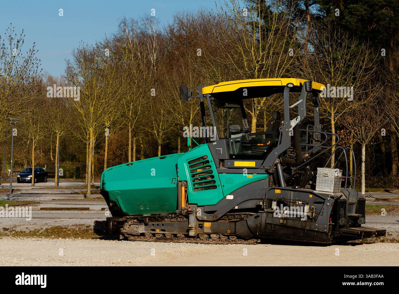 A large piece of construction equipment is parked in a park setting ...