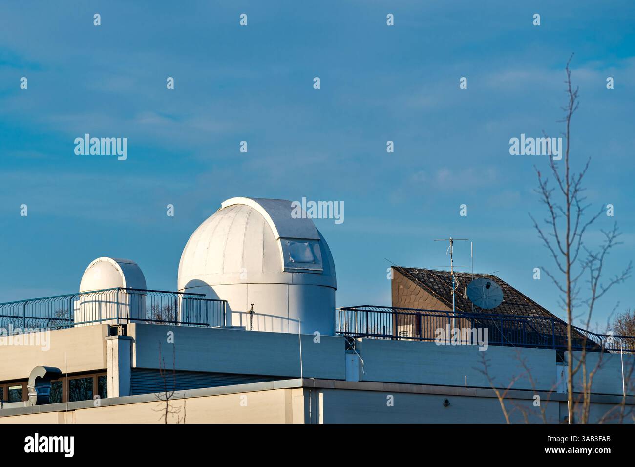 Two observatory domes sit atop a modern structure against a vibrant ...
