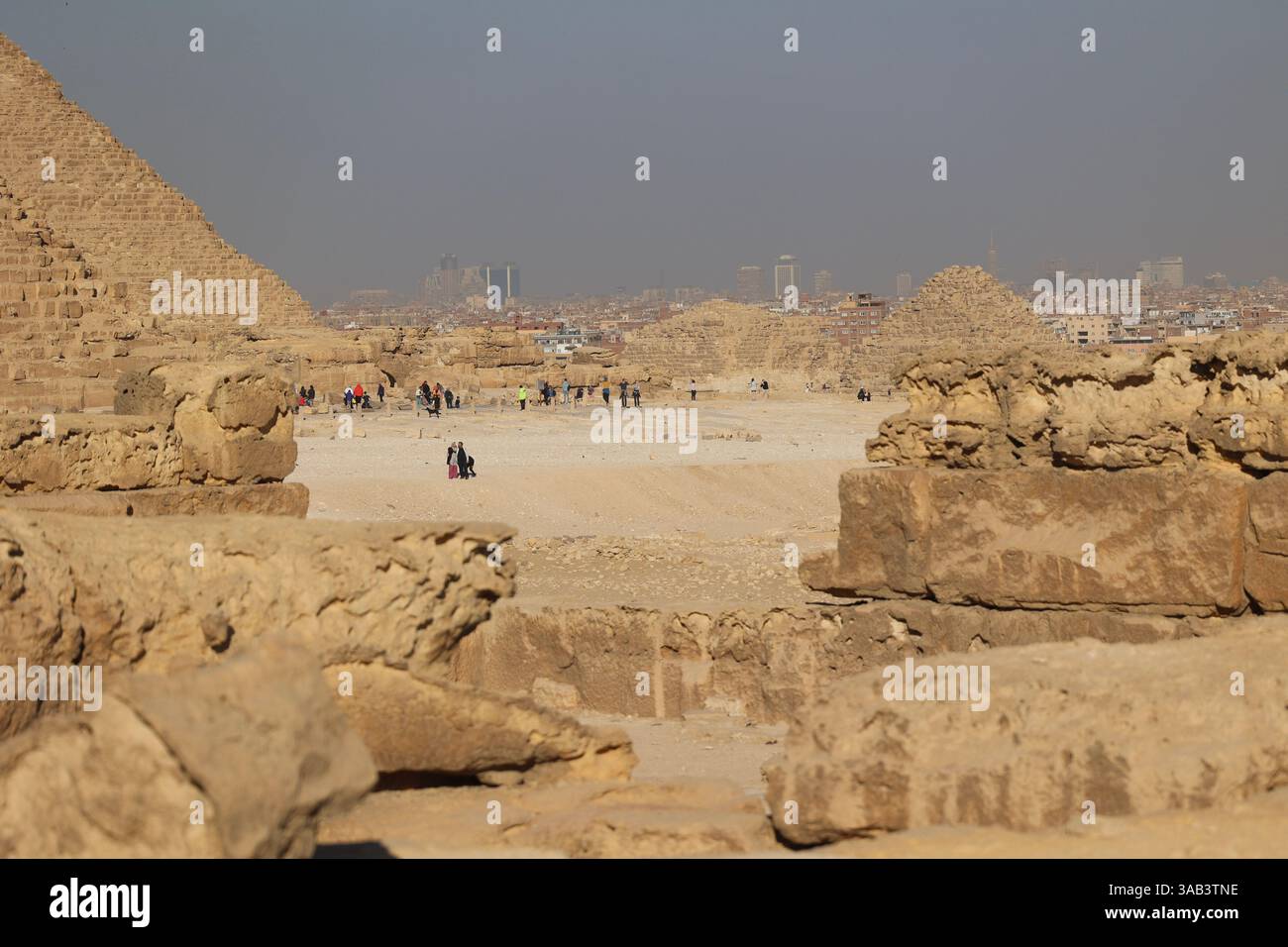group of tourists in the pyramid complex among ancient stones with high ...