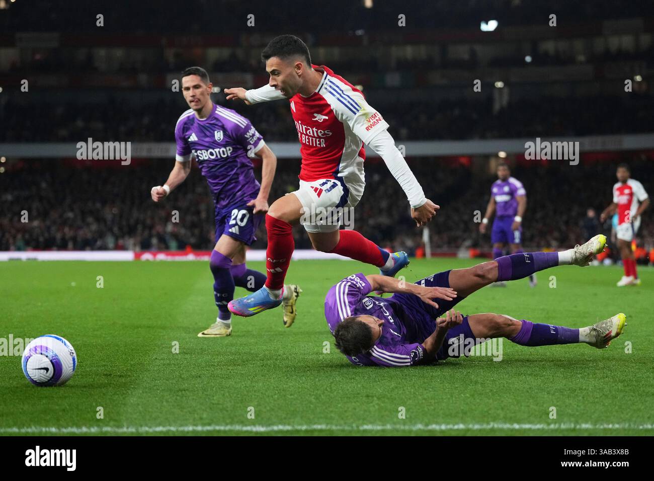 Arsenal's Gabriel Martinelli, center, duels for the ball with Fulham's ...