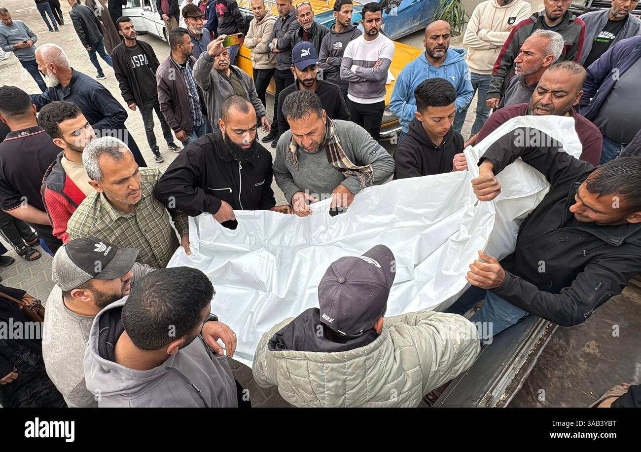 Bodies of Palestinians are brought to the Al-Aqsa Martyrs Hospital by their relatives for ...