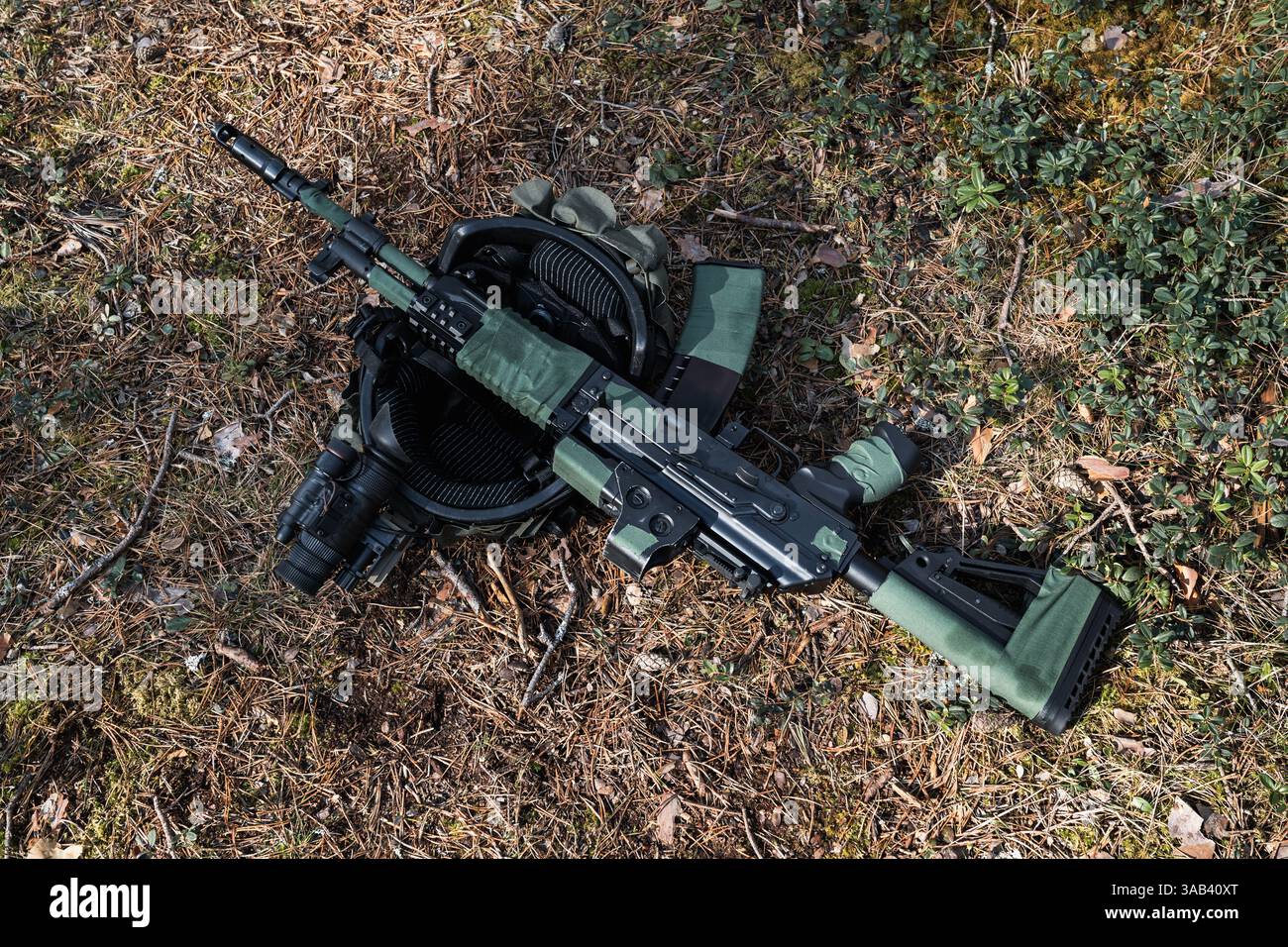 Tactical gear: modern assault rifle with optics and combat helmet with ...