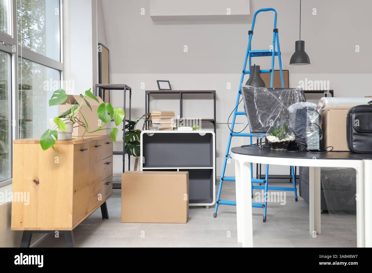 Interior of office with desk, boxes and stepladder on moving day Stock ...