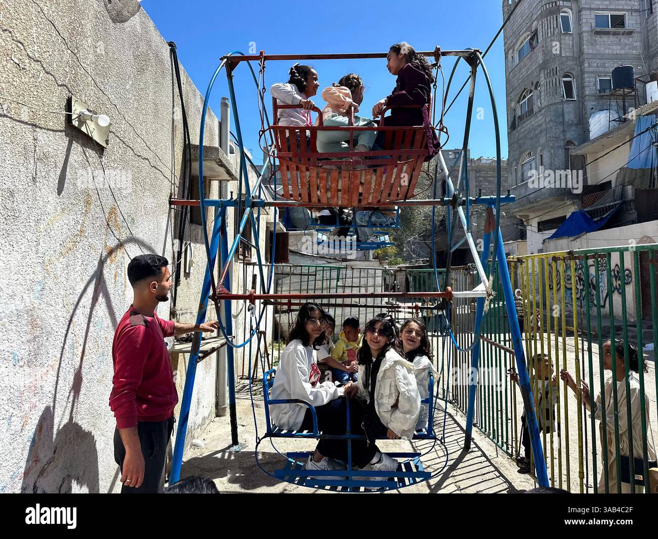 Palestinian children spend their time playing amidst the tents set up ...