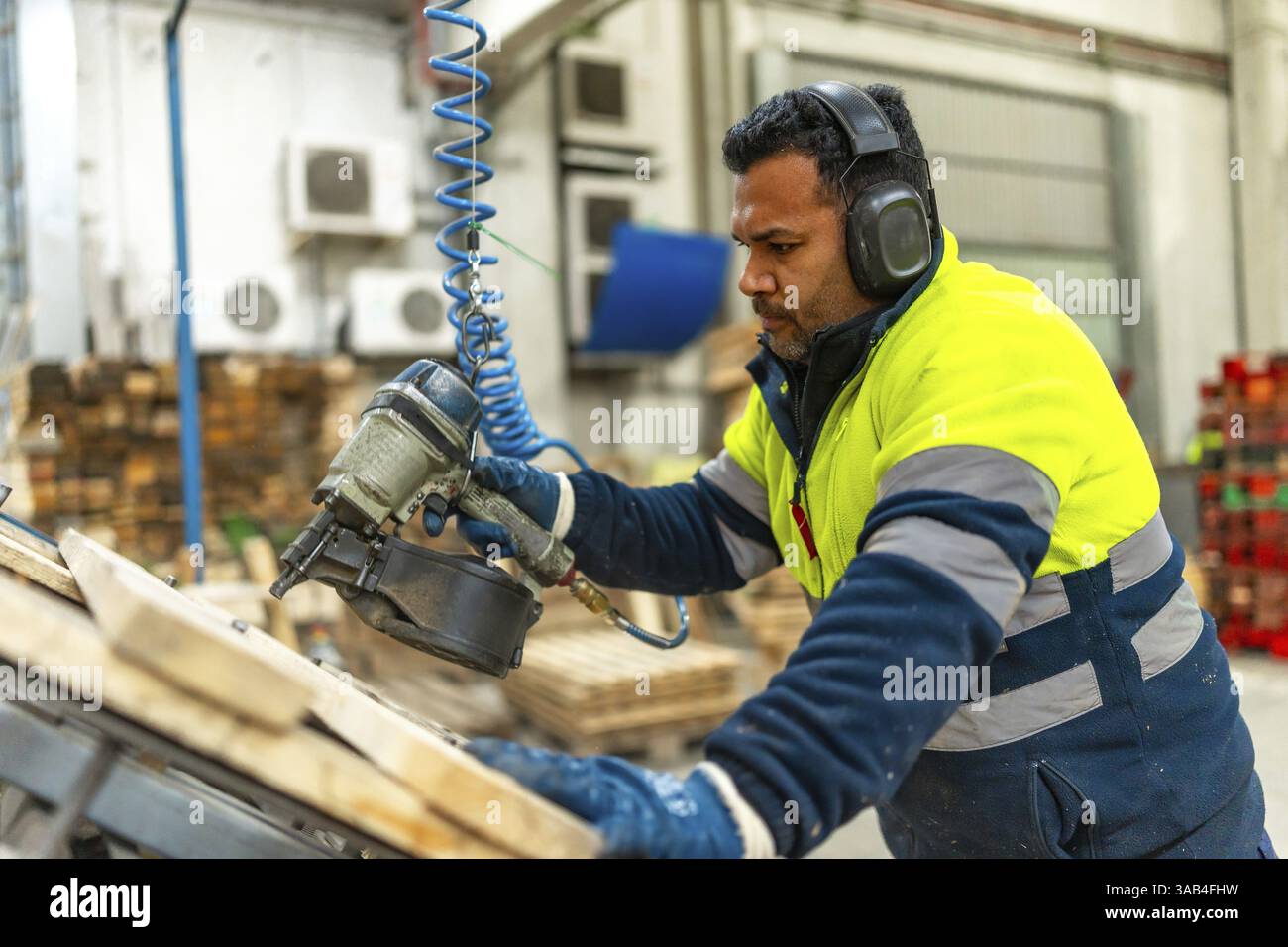 Side view of a caucasian adult man manual worker using compressed air ...
