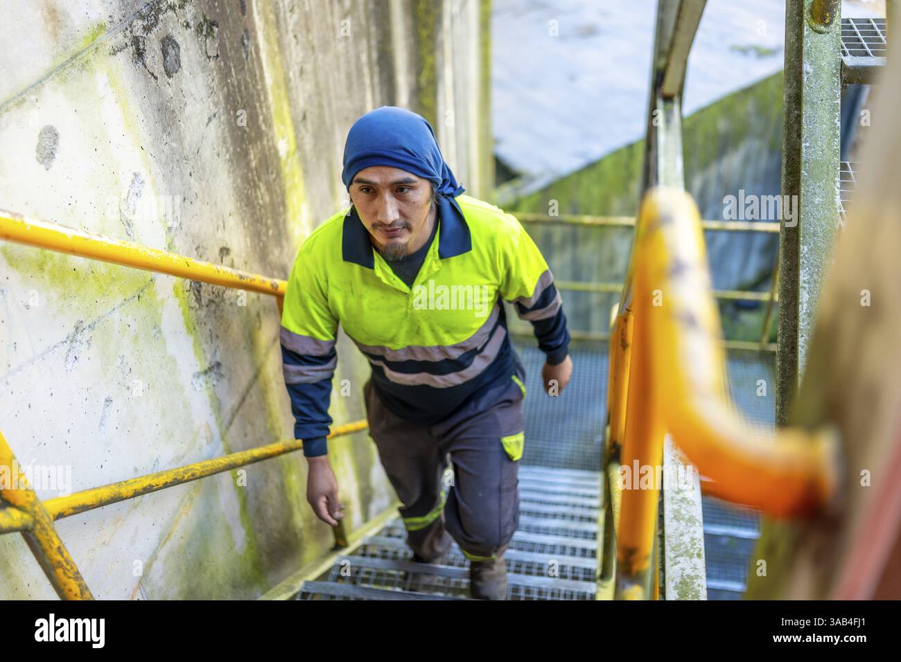 Top view of a latin man worker walking up stairs outside a recycling ...