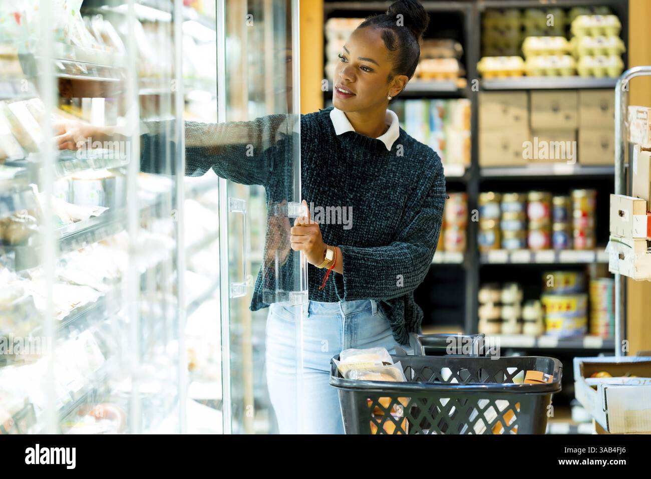 Customer selecting groceries from refrigerated section in supermarket ...