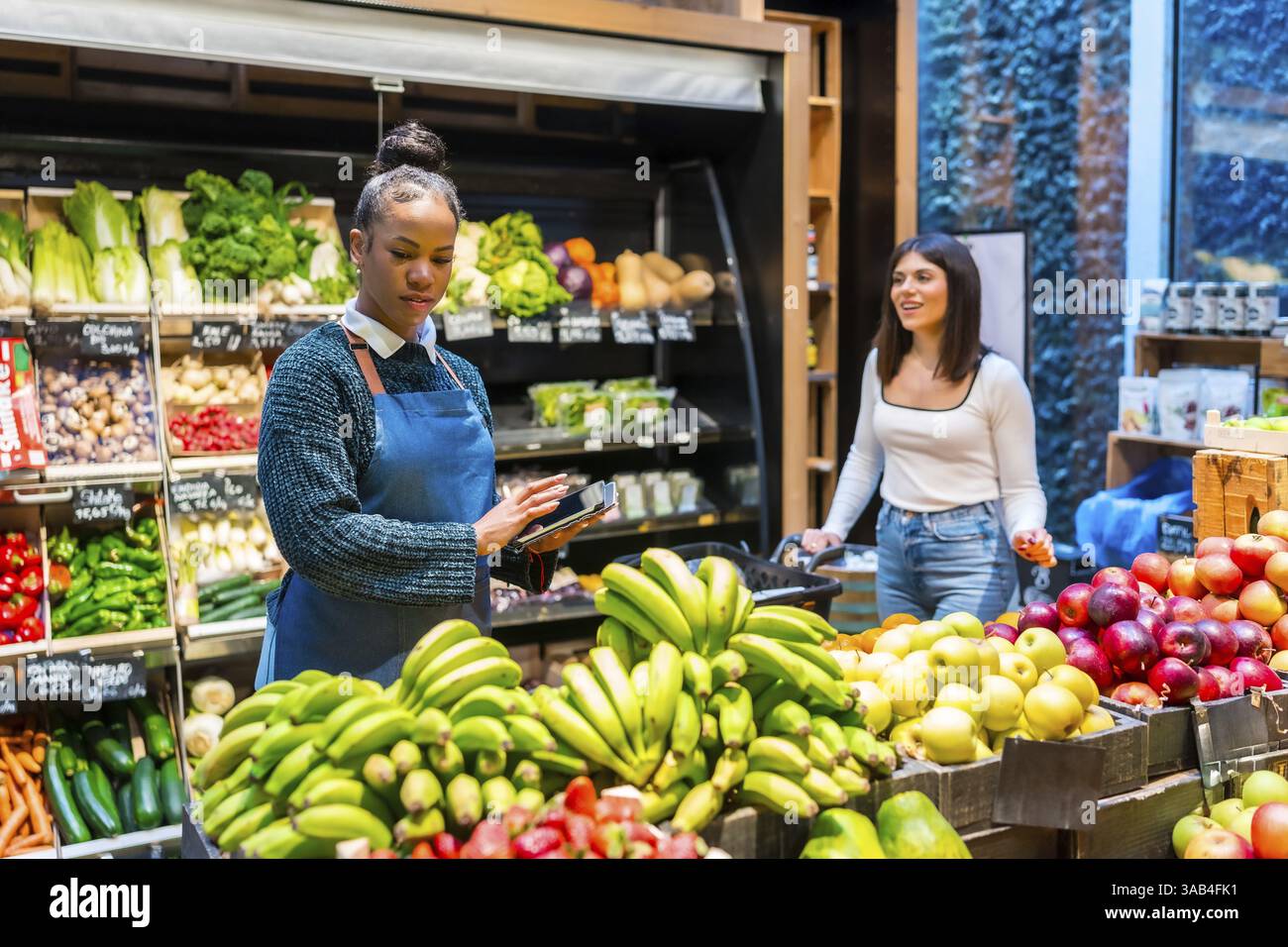 Grocery store employee using a digital tablet for inventory management ...