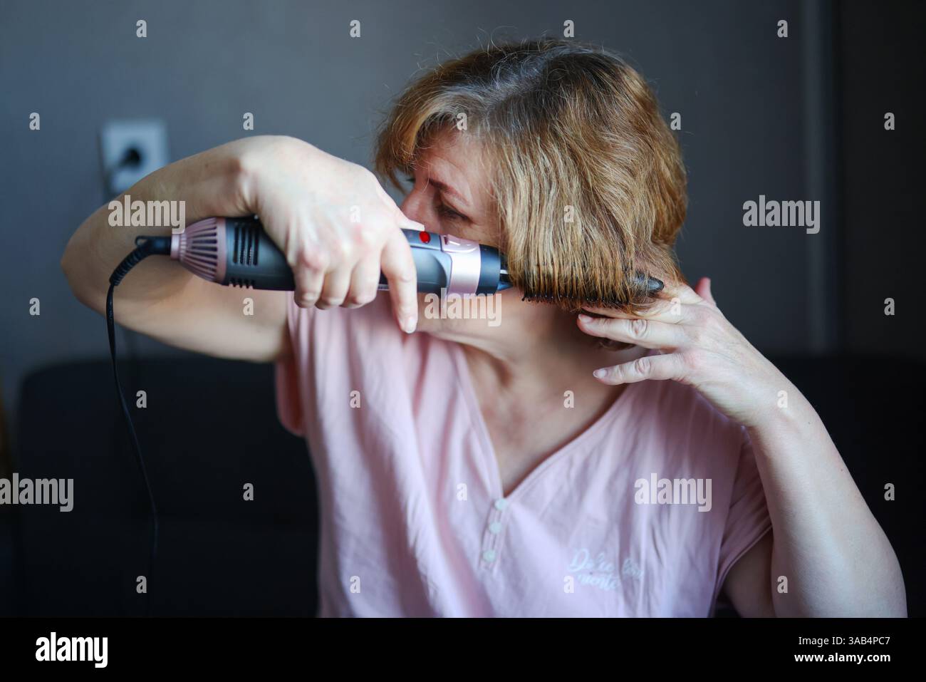 Senior woman drying styling hair hi-res stock photography and images ...