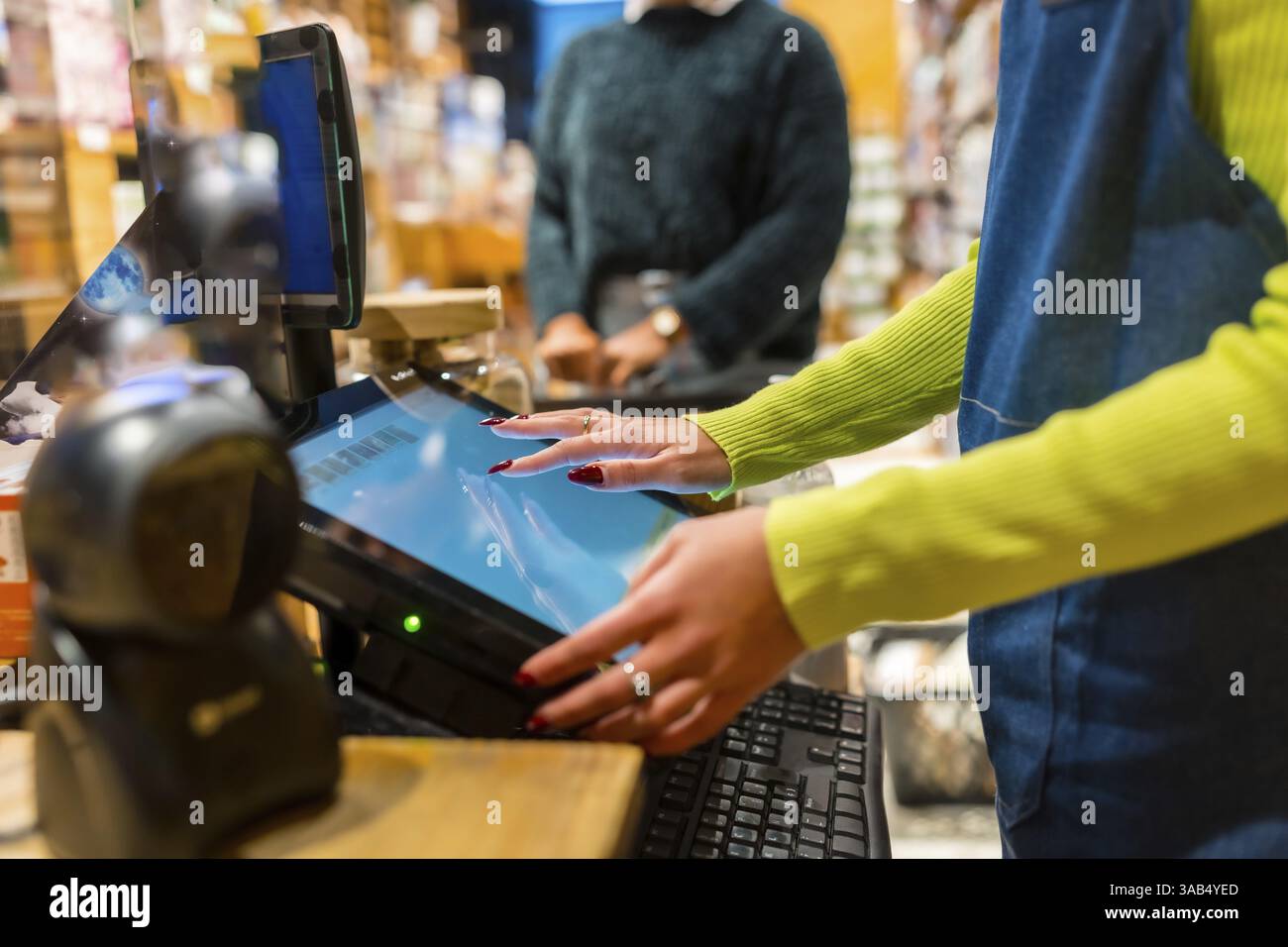Salesperson using a touch screen cash register in an organic ...