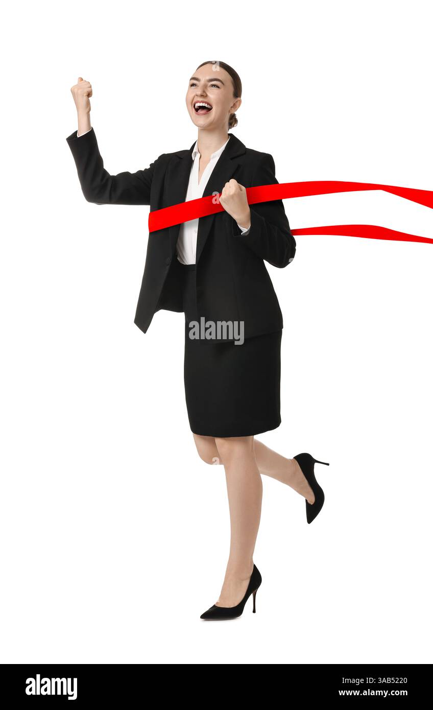 Happy businesswoman crossing red finish line ribbon on white background ...