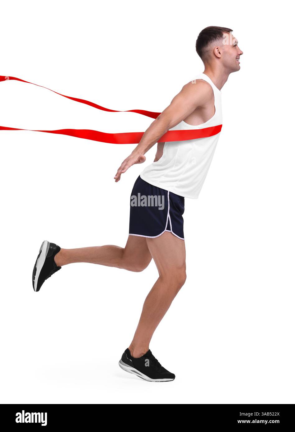 Happy sportsman crossing red finish line ribbon on white background ...