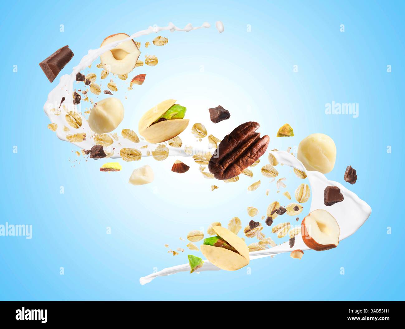 Oat flakes, nuts, chocolate crumbs and splashing milk in air on light ...