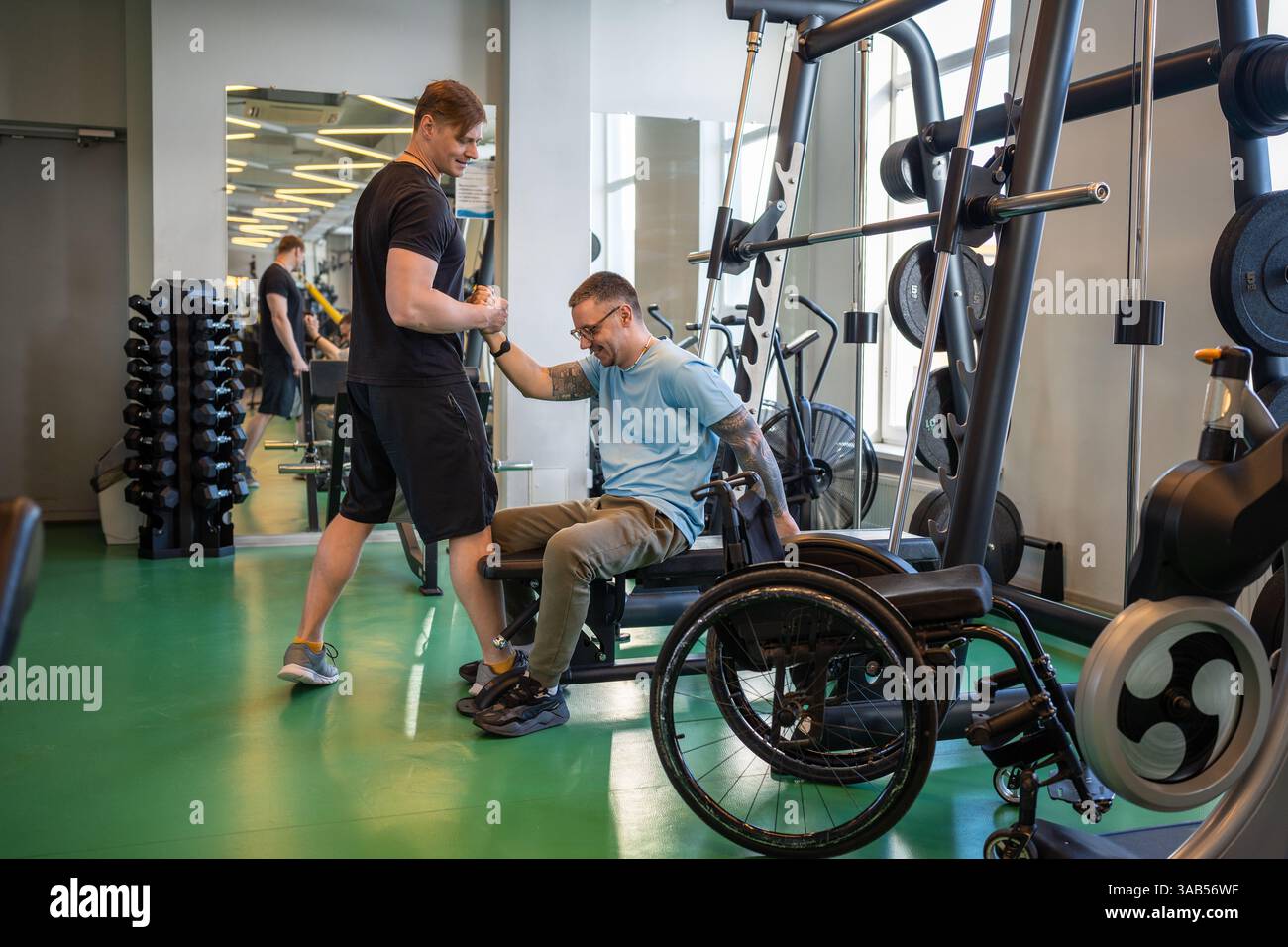 Caring sports coach aid athlete in wheelchair transfer after completing ...