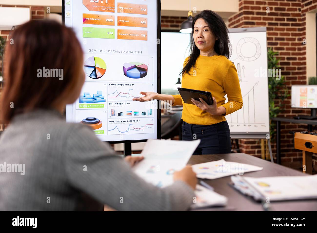 Asian female analyst points hi-res stock photography and images - Alamy